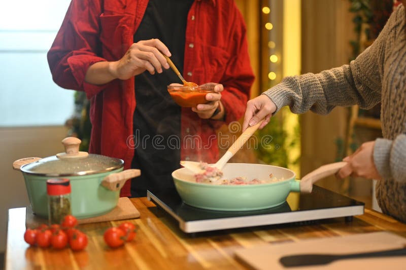 Couple Cooking Together with Christmas Lights in the Background Stock ...