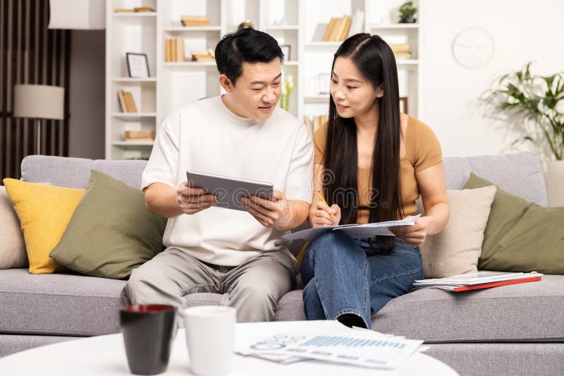 Couple Discussing Finances with Tablet and Documents at Home Stock ...