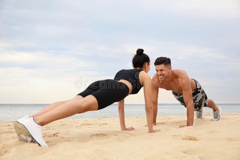 Couple Doing Exercise Together on Beach. Body Training Stock Image ...