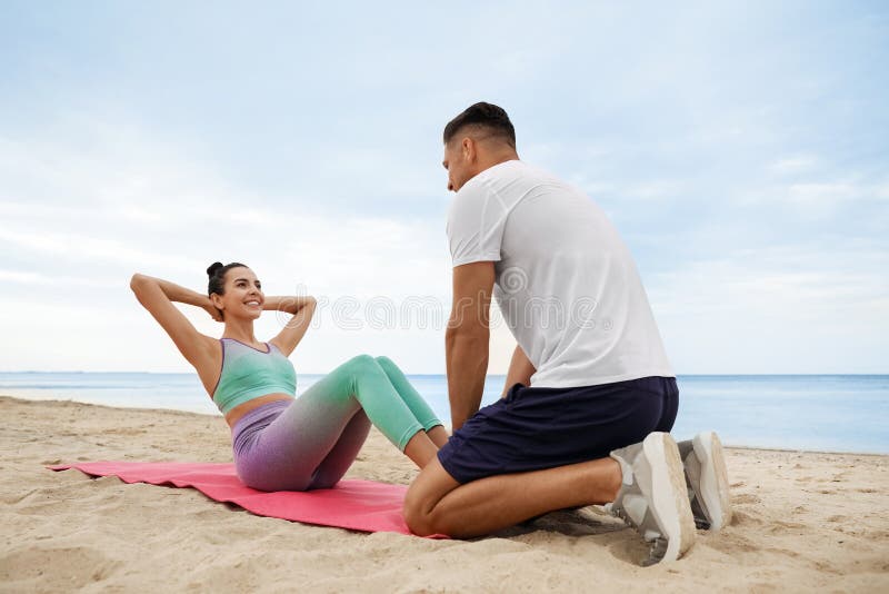 Couple Doing Exercise Together on Beach. Body Training Stock Image ...