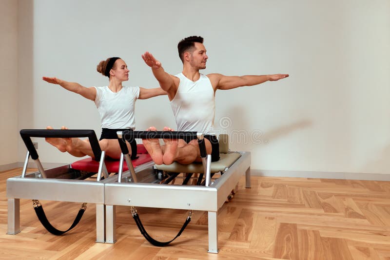 Couple Doing Pilates on a Reformer, Group Pilates Training in a Studio ...