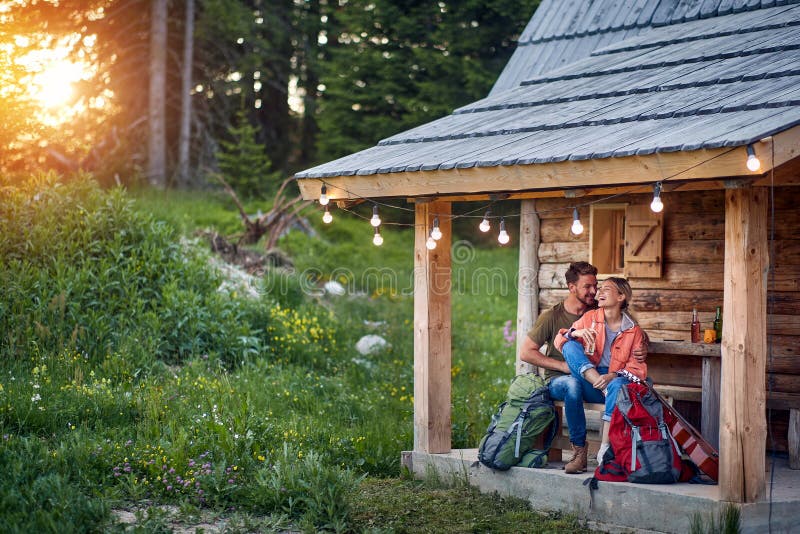 Couple Drinking in Front of Wooden Cottage on the Terrace Stock Photo ...
