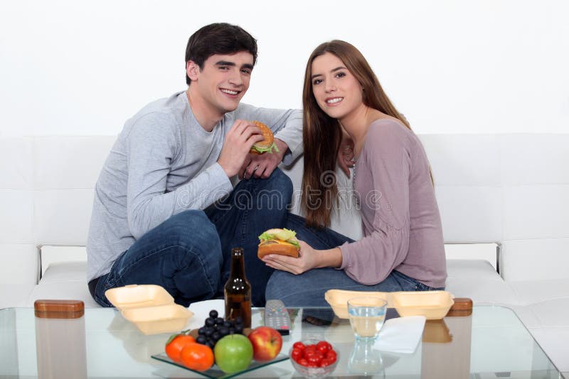 Couple eating fast food stock image. Image of couch, inside - 27809861