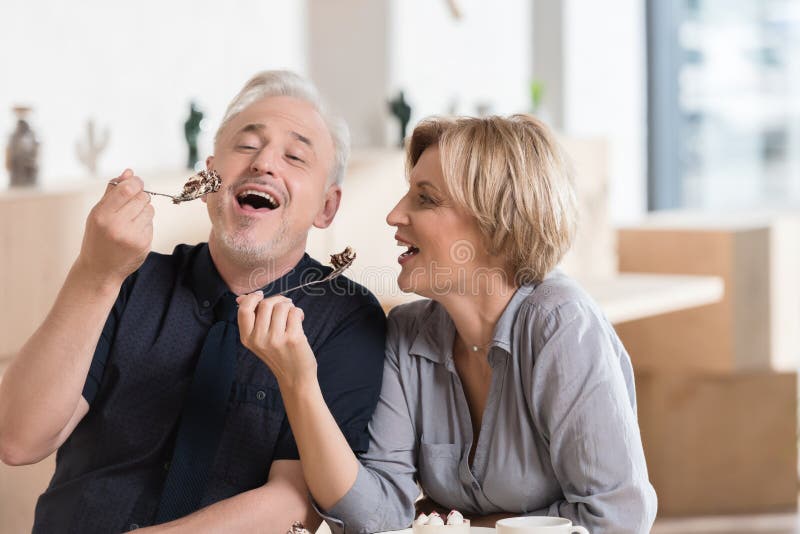 Affectionate Couple Laughing and Eating Sweets at Cafe Stock Photo ...