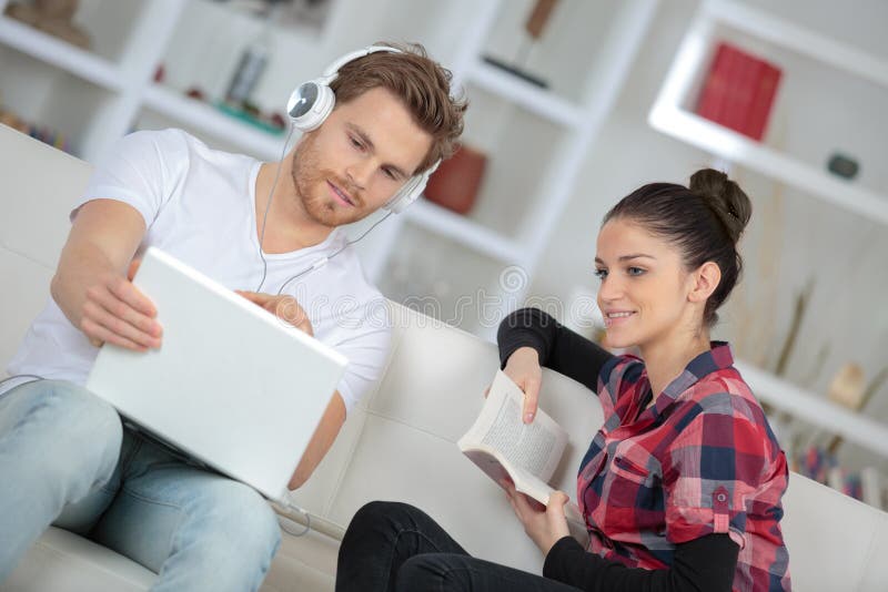 Couple with Electronic Book and Laptop in Sofa Stock Image - Image of ...