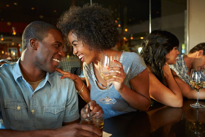 Couple Enjoying Drink at Bar with Friends Stock Photo - Image of group ...
