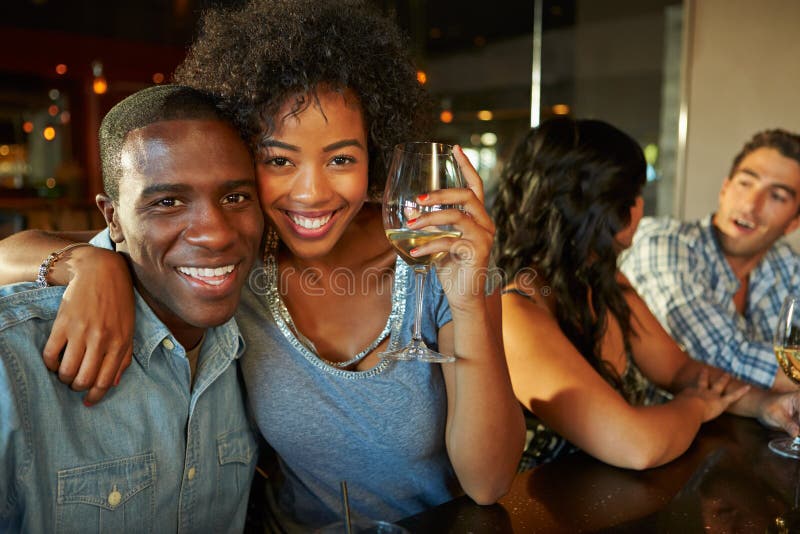 Couple Enjoying Drink at Bar with Friends Stock Image - Image of ...