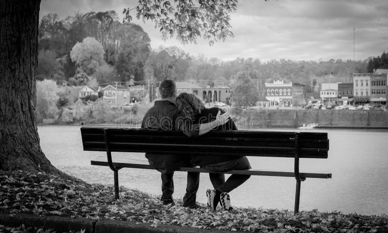 Couple Enjoying a Sunny Day Outdoors on a Park Bench by a Waterfront ...