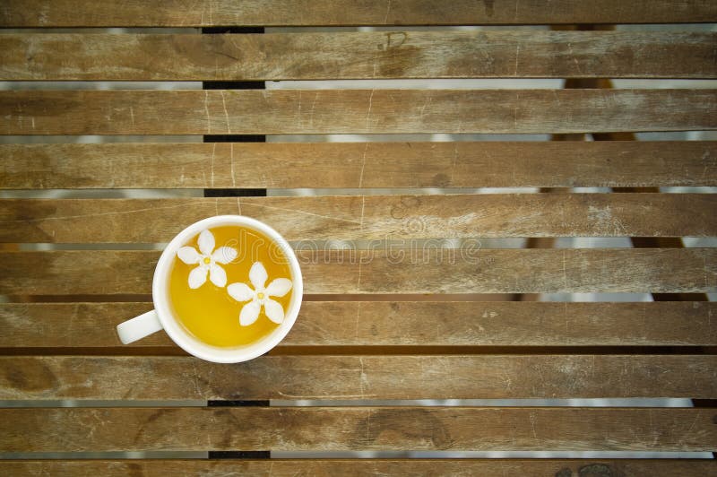 Couple of Falling White Flowers in Tea Cup on Wooden Table Stock Photo ...