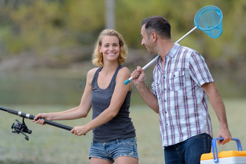 Couple Fishing or Angling Standing on River Shore in Grass Stock Photo ...
