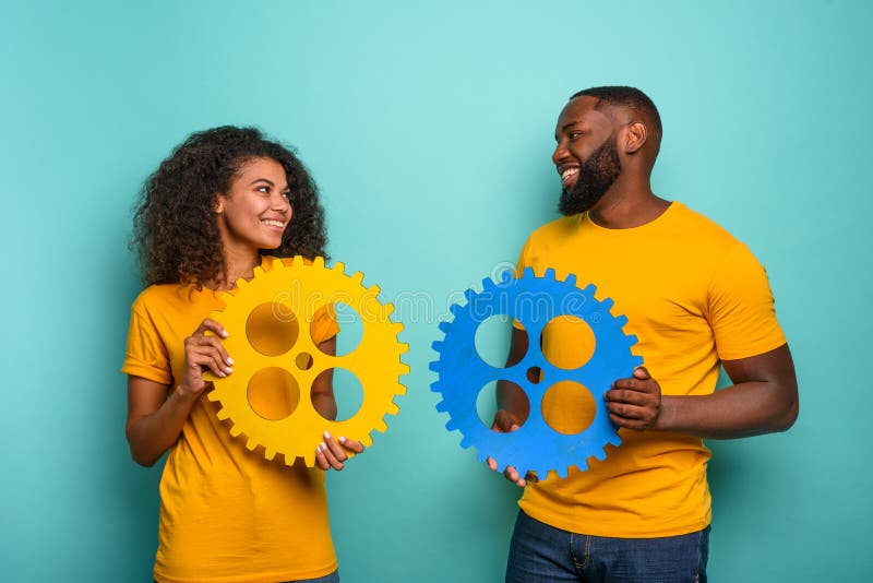 Couple with Gears in Hand Over Light Blue Background. Concept of ...