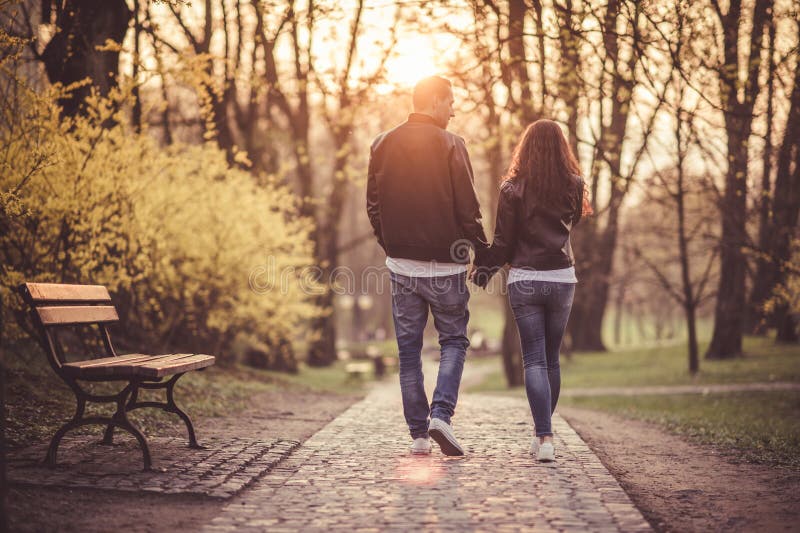 Couple Holding Hands Walking Towards Sunset. Love Theme Stock Photo ...
