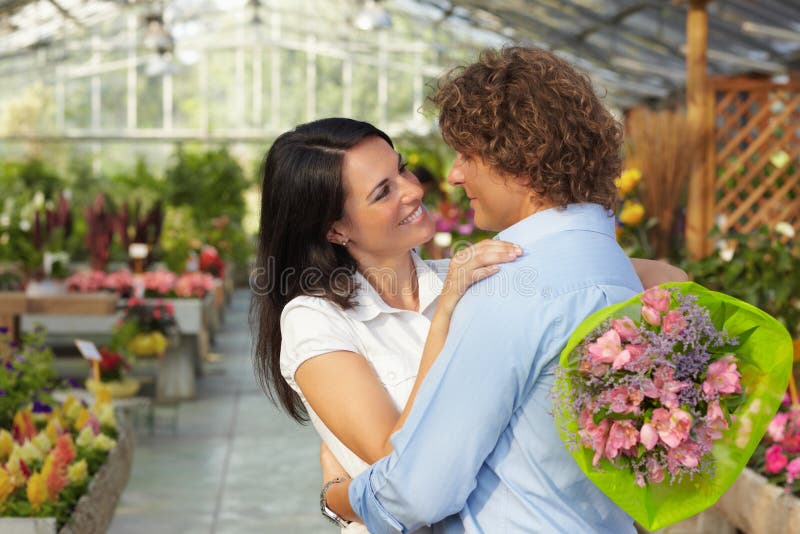 Couple Hugging in Flower Nursery Stock Photo - Image of garden, passion ...