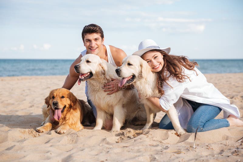 Couple Hugging Three Dogs and Sitting on the Beach Stock Image - Image ...