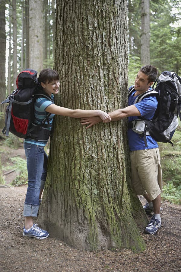 Couple Hugging Tree in Forest Stock Photo - Image of enjoyment ...