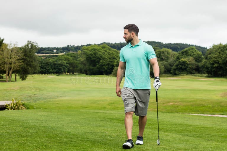 Man Wearing Golf Attire Walking Across Fairway with Club, Glove and ...