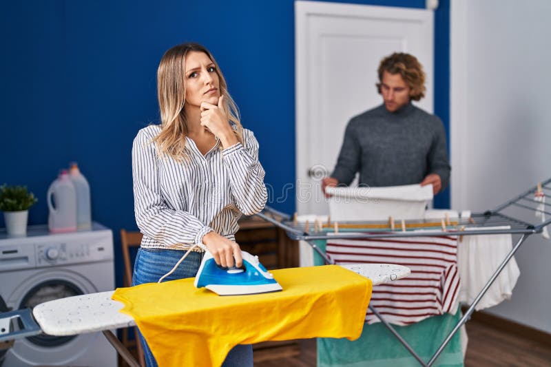 Couple Ironing Clothes at Laundry Room Serious Face Thinking about ...