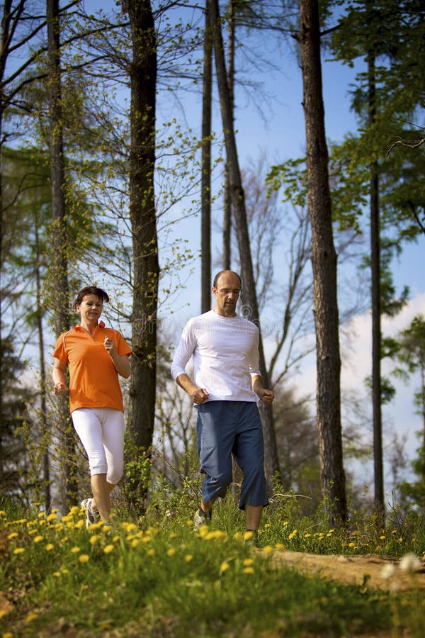Couple Jogging In Forest, View From Behind. Stock Image - Image of ...
