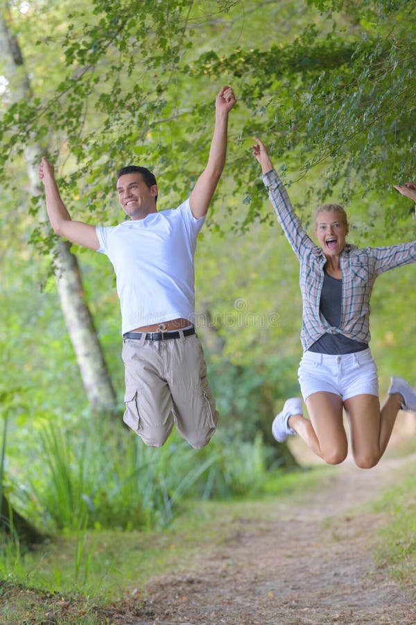 Couple jumping on path stock image. Image of blue, together - 102666607