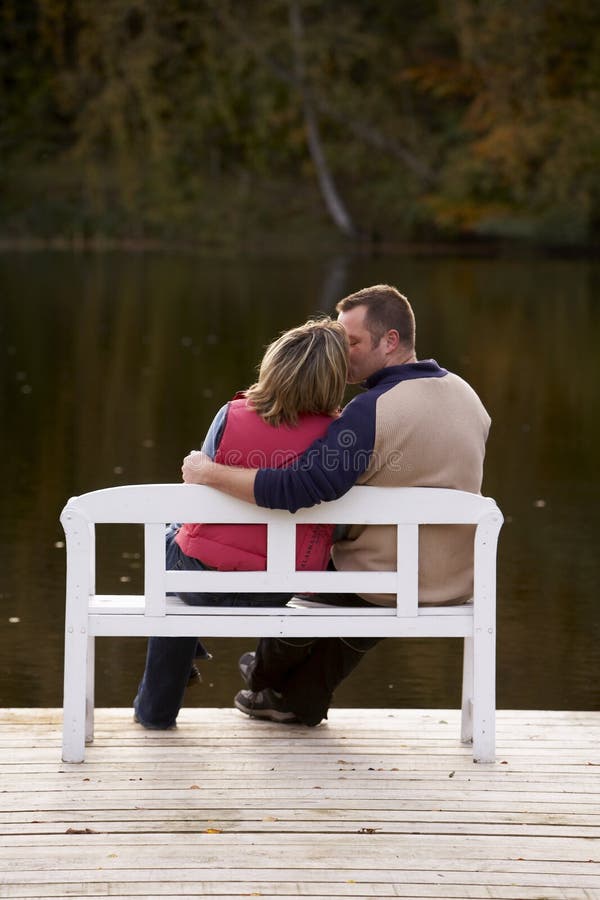 Couple kissing on a bench stock photo. Image of monogamous - 7525332