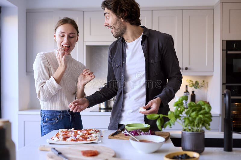 Couple in Kitchen at Home Making Homemade Pizza Together Stock Photo ...