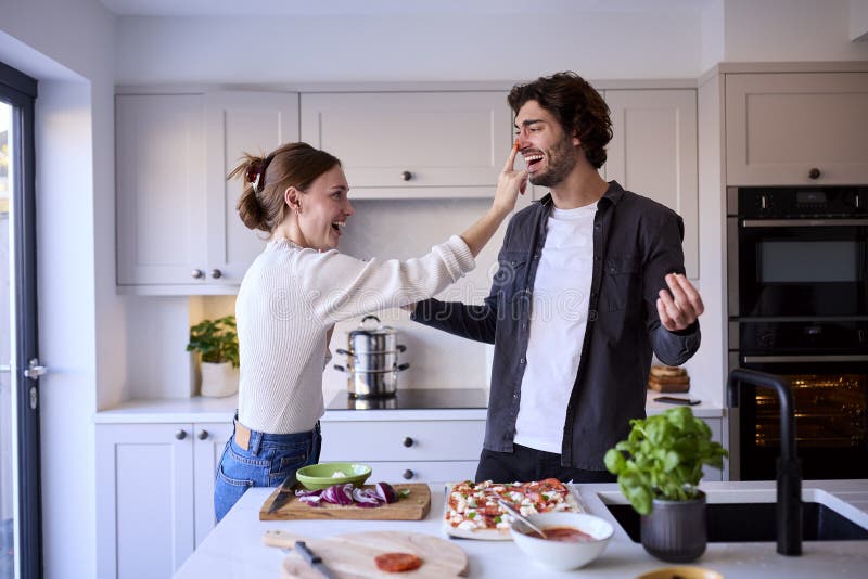 Couple in Kitchen at Home Making Homemade Pizza Together Stock Photo ...