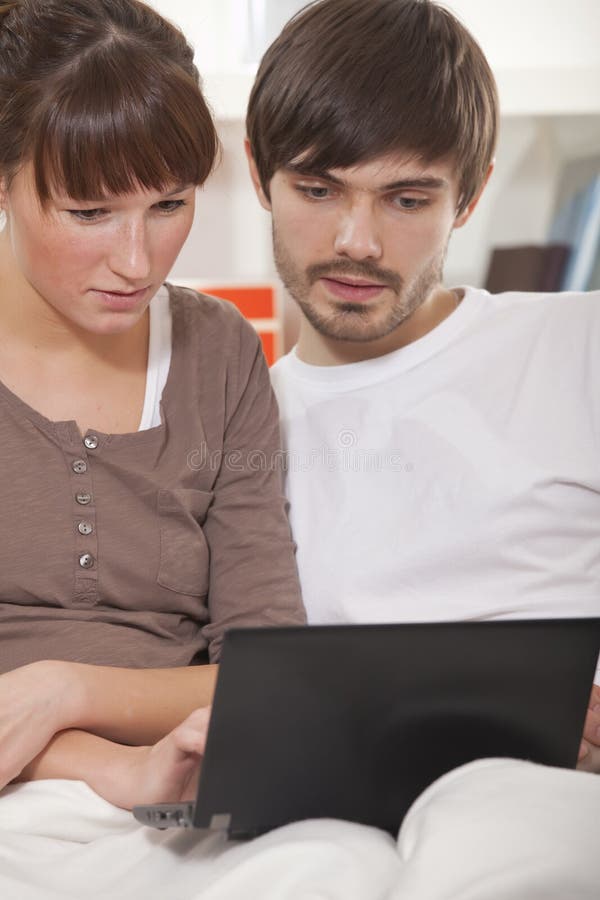 Couple with laptop at home stock image. Image of male - 17541145