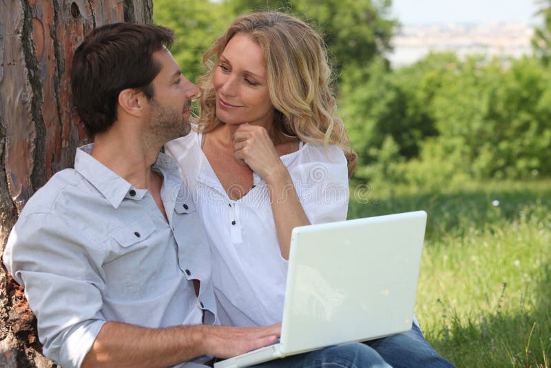 Couple with a Laptop Outside Stock Photo - Image of kiss, handsome ...