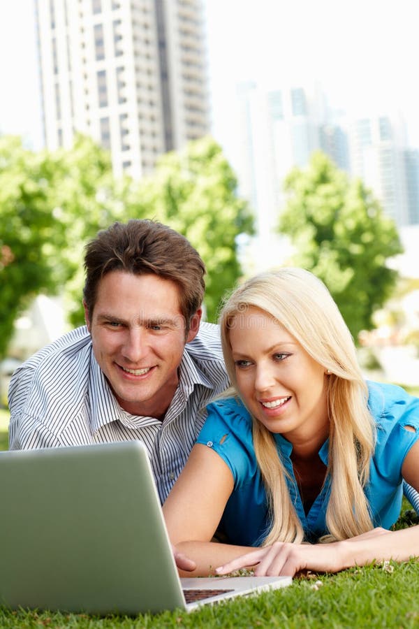 Couple on laptop in park stock photo. Image of laptop - 20892692