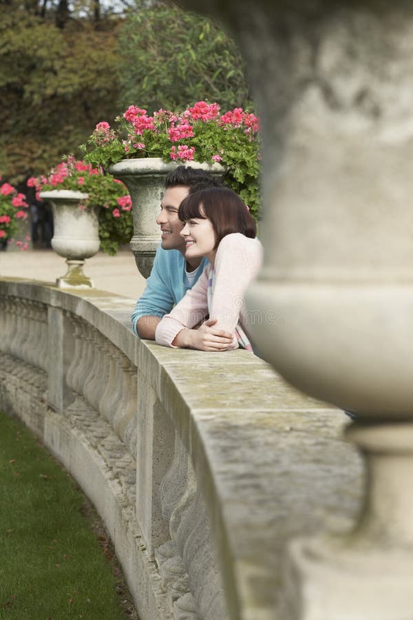 Couple Looking Over Wall by Potted Plants Stock Photo - Image of dayout ...