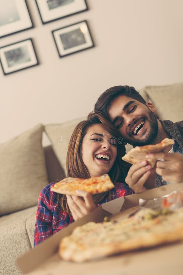 Couple eating pizza stock image. Image of home, food - 112230149