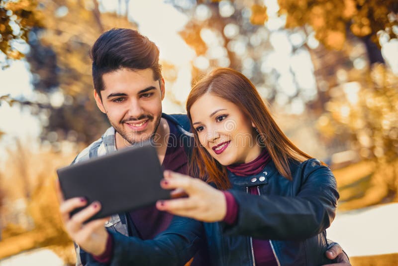 Couple in Love Lifestyle Outdoor Using Tablet at the Park Stock Image ...