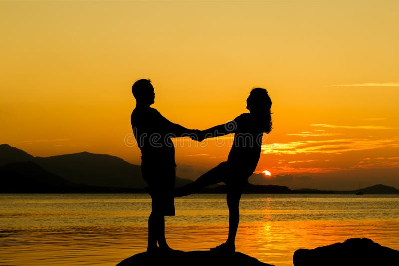 Couple Love Standing on the Stone Looking Sunset at Stock Photo - Image ...