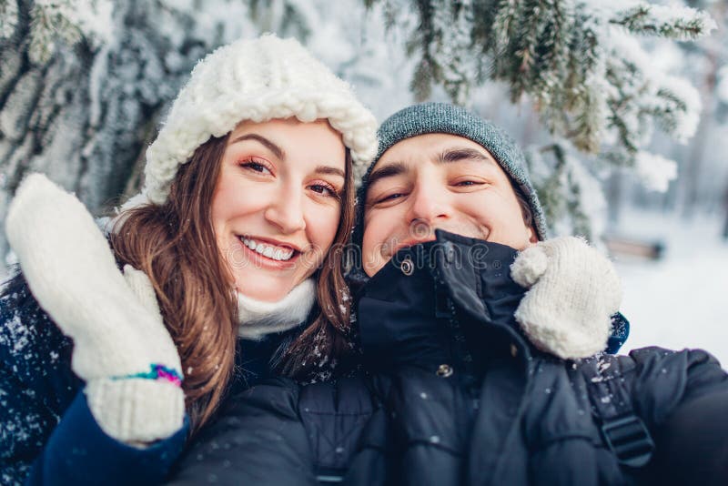 Couple In Love Taking Selfie And Hugging In Snowy Winter Forest Young