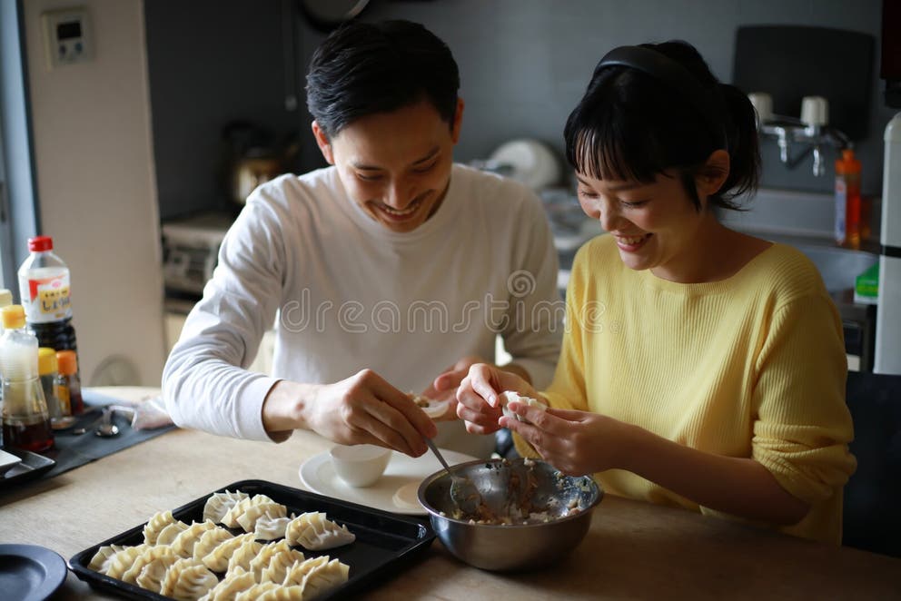 A couple making dumplings stock image. Image of body - 241690949