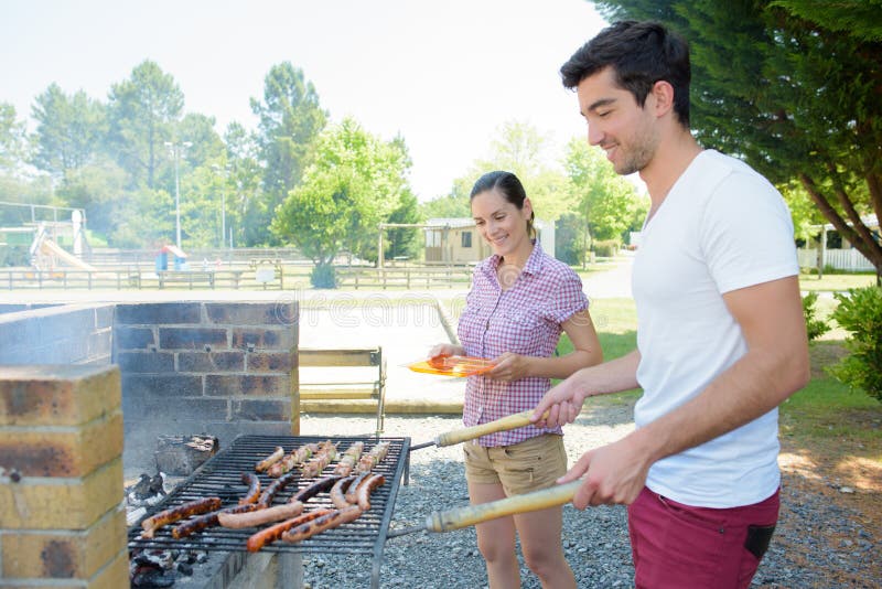 Couple Making Giant Barbecue Stock Image - Image of burned, barbecue ...