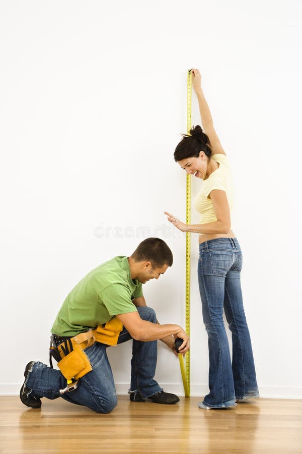 Couple measuring wall. stock photo. Image of helping, indoors - 3532976