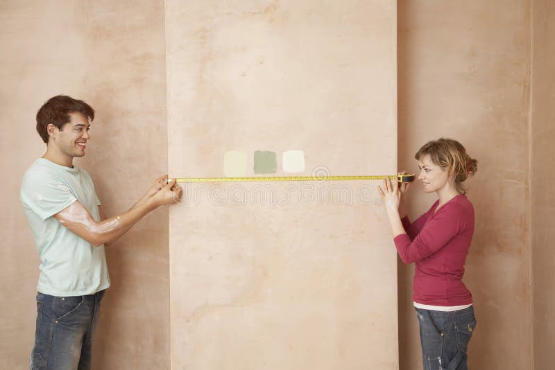 Couple Measuring Wall with Tape Stock Photo - Image of couple ...