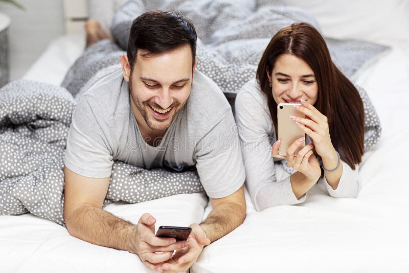 Couple with Mobile Phone in Bed in the Morning Stock Image - Image of ...