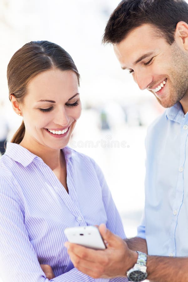 Couple with mobile phone stock photo. Image of confident - 32804692