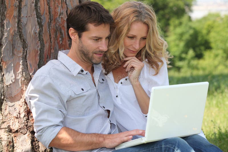 Couple on laptop on bench stock image. Image of portrait - 20430647