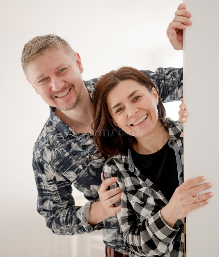 Couple Peeking Out from Behind Door Stock Photo - Image of eyes, look ...