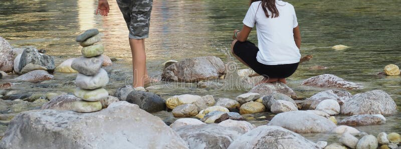 Couple of People Walking and Sitting on the Rocks by the River Stock ...