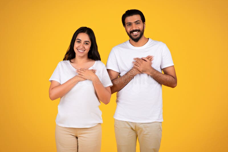 Couple Placing Hands on Heart, Yellow Background Stock Image - Image of ...