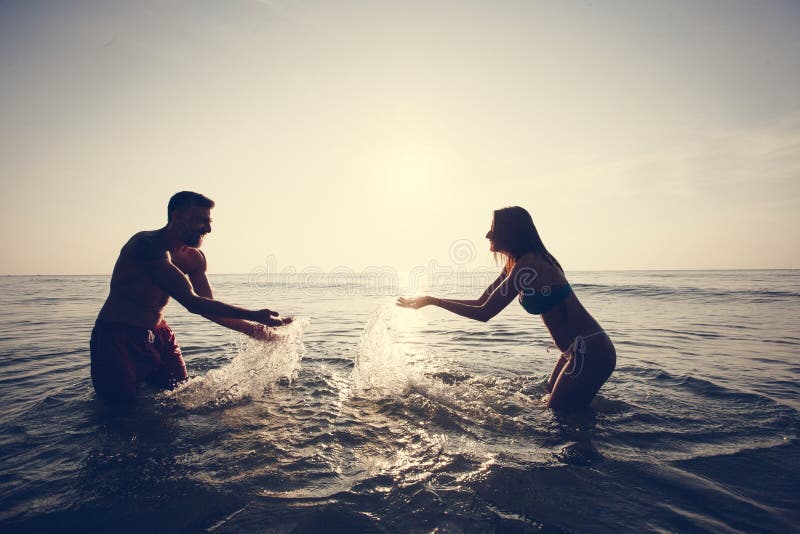 Couple Playing in the Water Stock Photo - Image of island, american ...