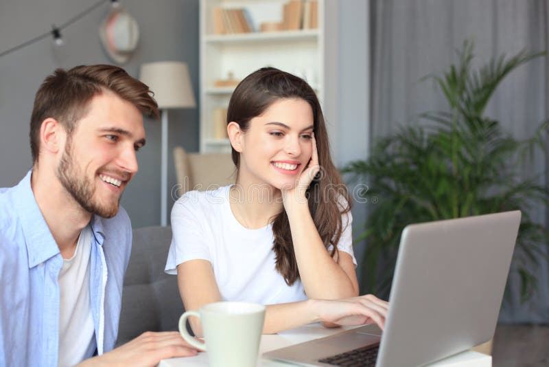 Couple Pointing while Working Together on Laptop Stock Photo - Image of ...