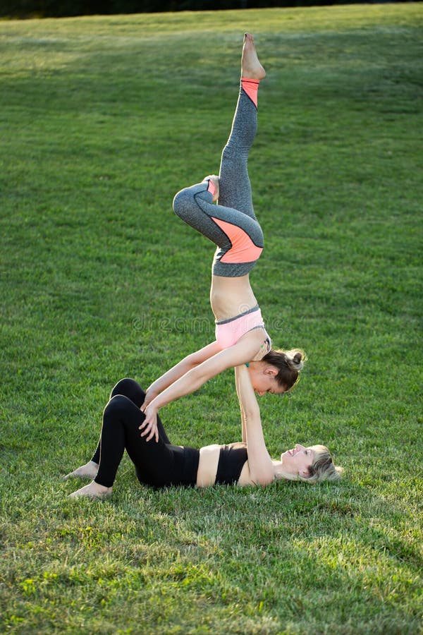 The Couple Practices Acro Yoga in the Park on the Grass. Stock Image ...