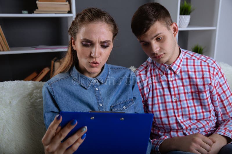 Couple Reading Documents Sitting on the Sofa at Home. Stock Photo ...
