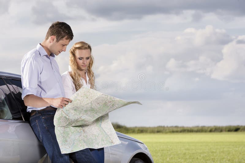 Couple Reading Map while Leaning on Car at Countryside Stock Photo ...