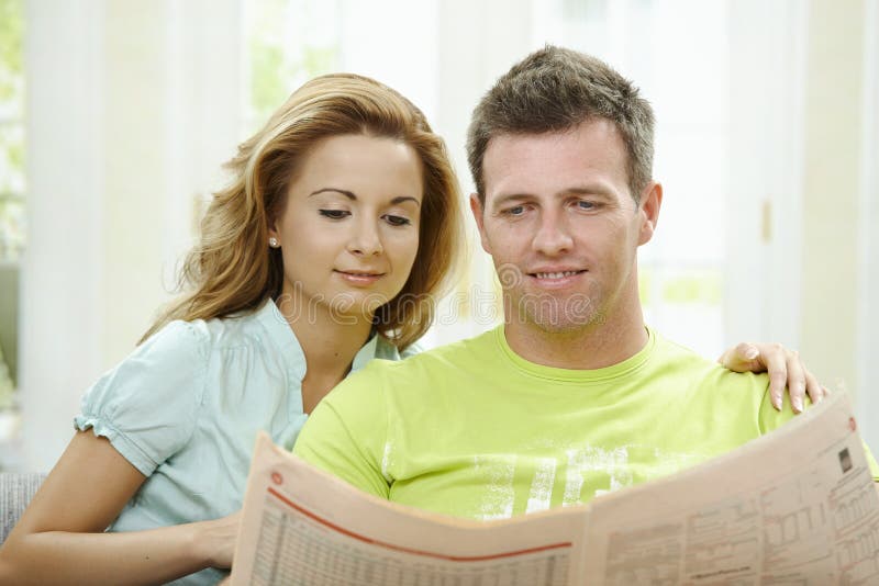 Couple reading newspaper stock image. Image of home, couch - 12882983